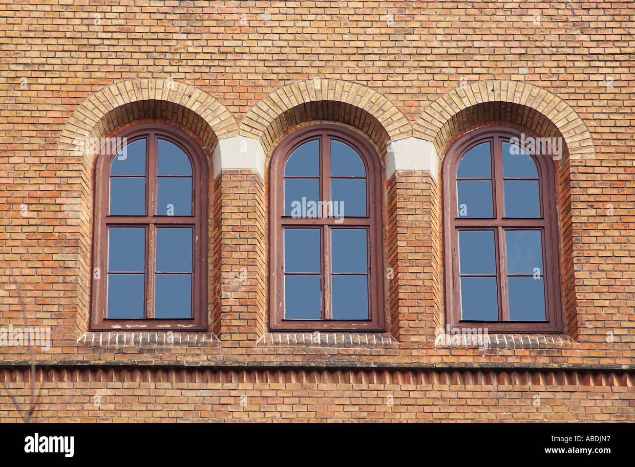 three windows in a brick building Stock Photo - Alamy