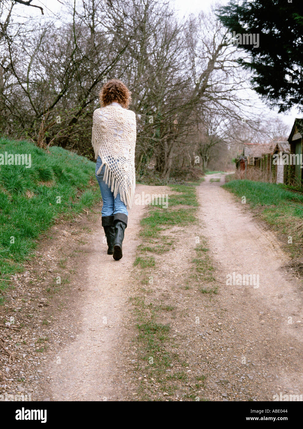 Woman walking on a country road Stock Photo - Alamy