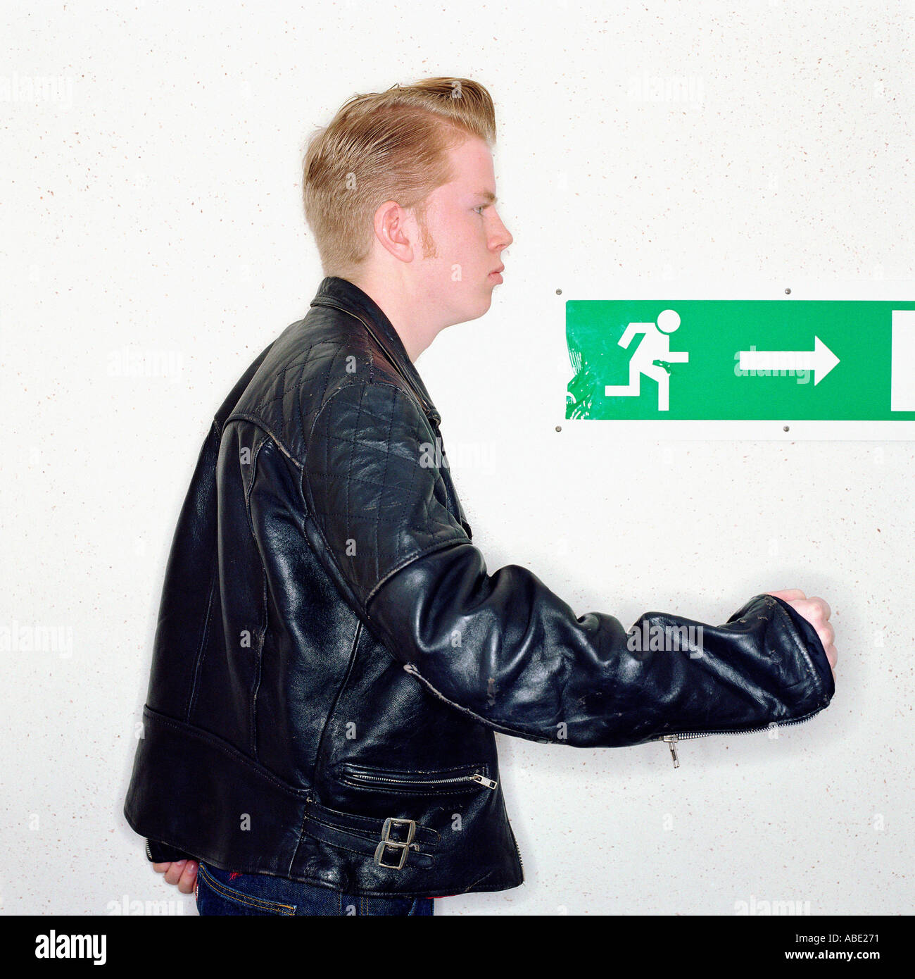 Boy walking past exit sign Stock Photo - Alamy
