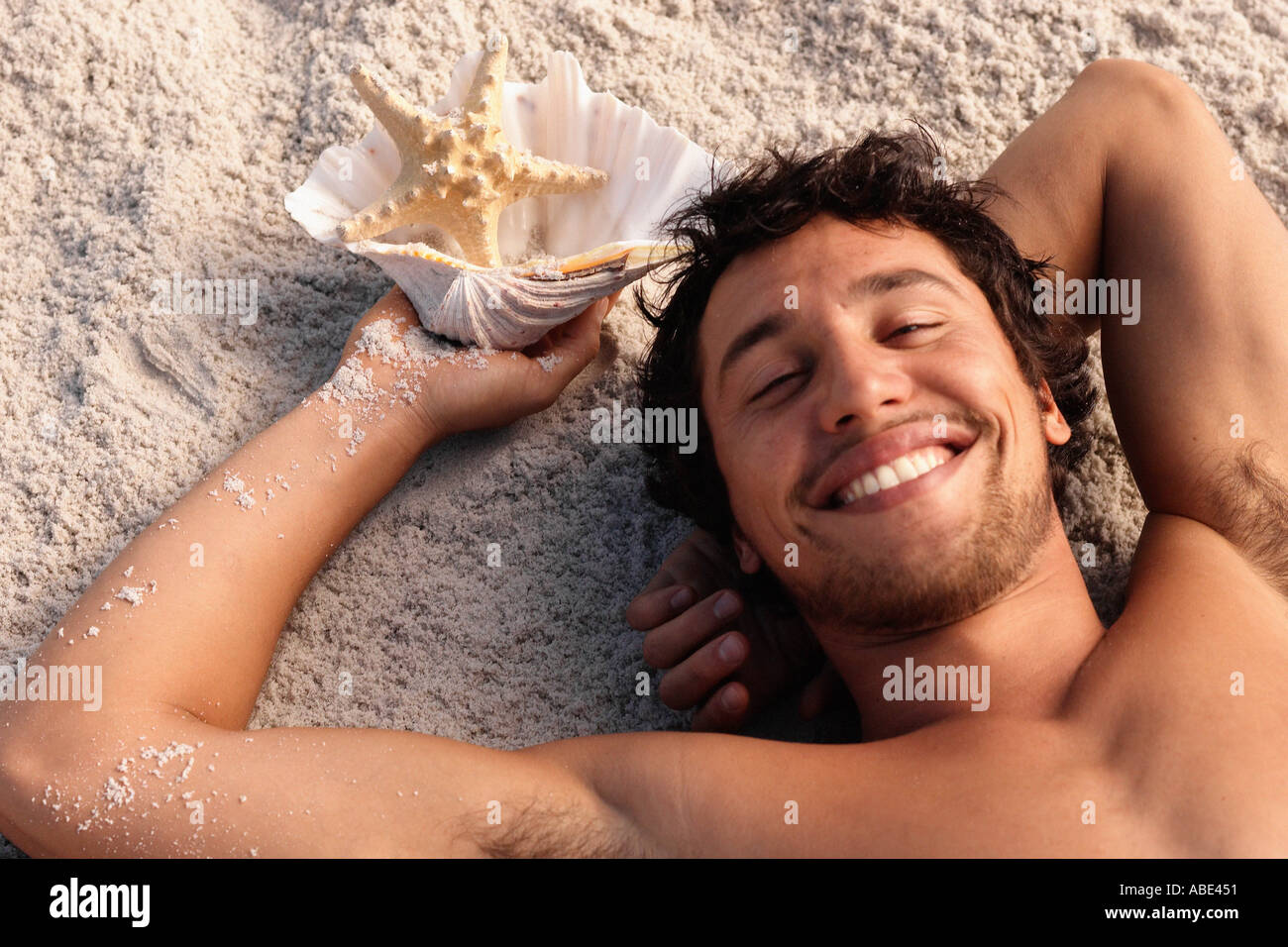 Happy man lying on a beach Stock Photo - Alamy