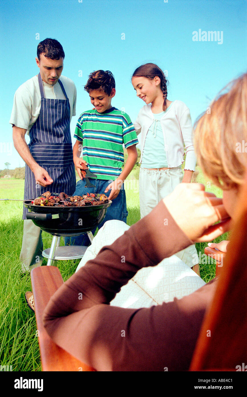 Family cooking food on barbeque Stock Photo - Alamy