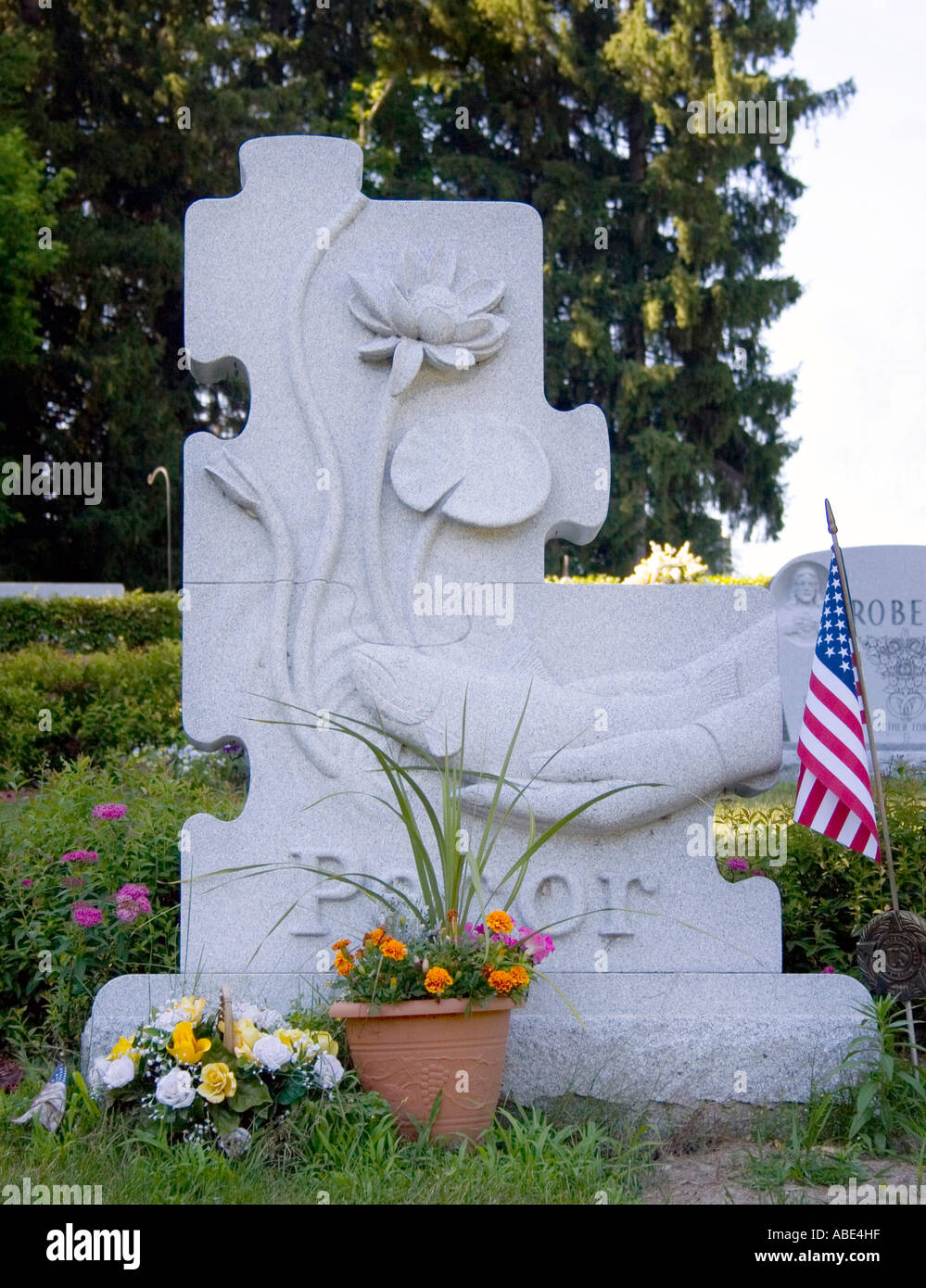 Hands holding a fish puzzle piece gravestone at the Hope Cemetery in ...