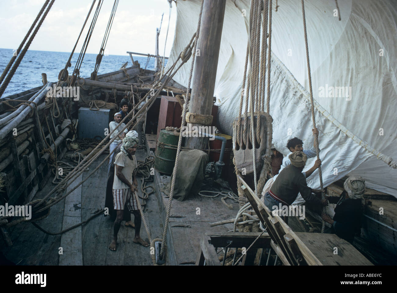 Sailors hauling, the big four-sheave block of the Arab dhow's halyard ...