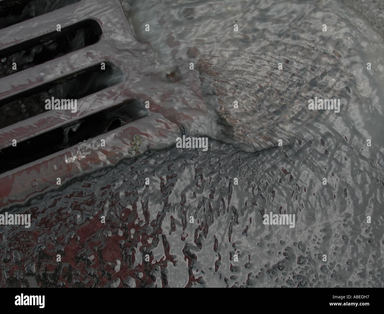 water rain running into sewerage through a gully on street Stock Photo ...