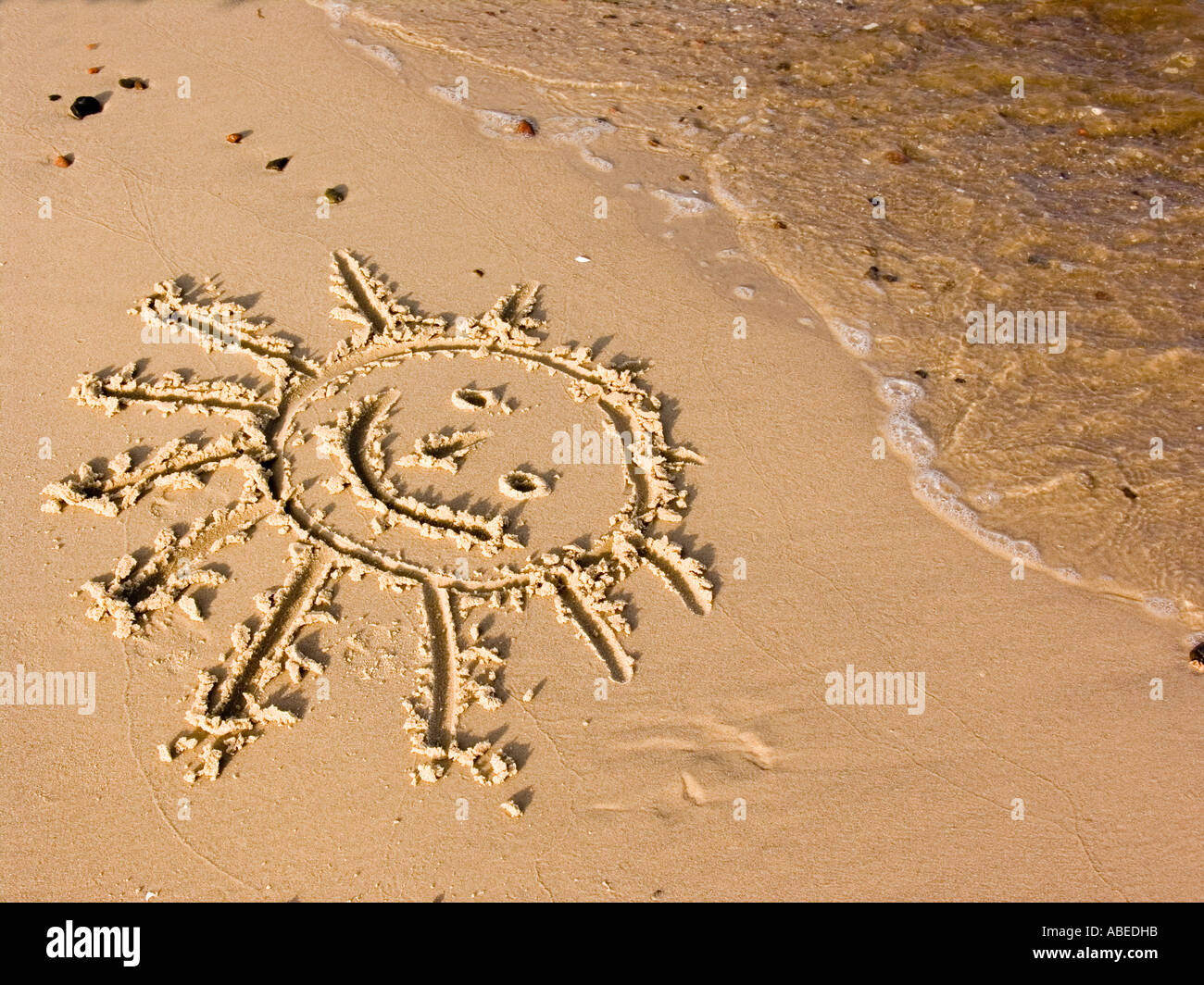 picture drawing of sun on sand on a beach near to water Stock Photo - Alamy