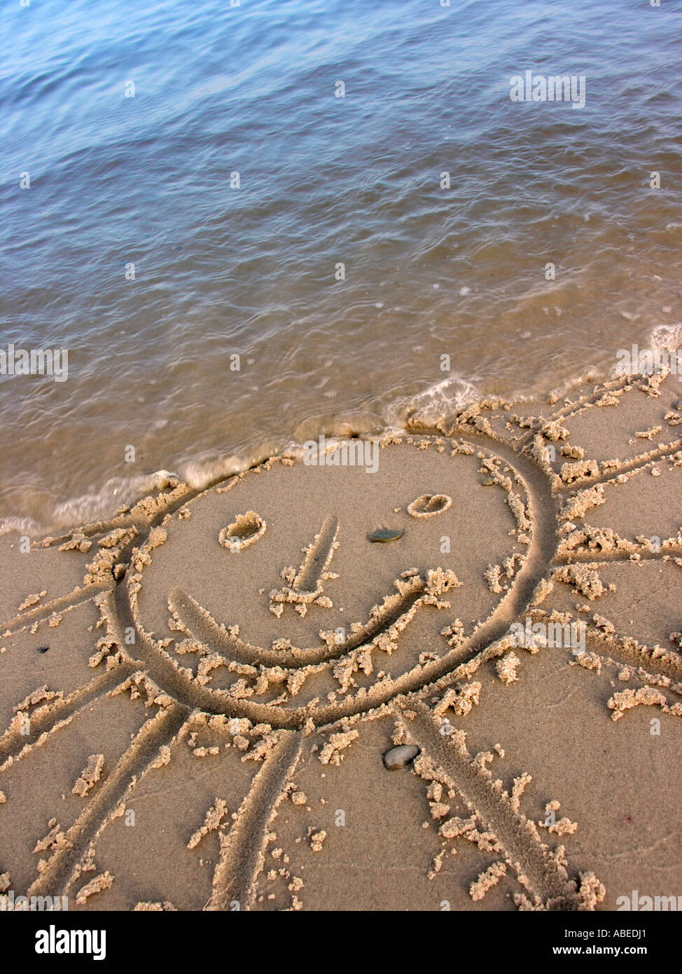 picture drawing of sun on sand on a beach near to water getting wished ...