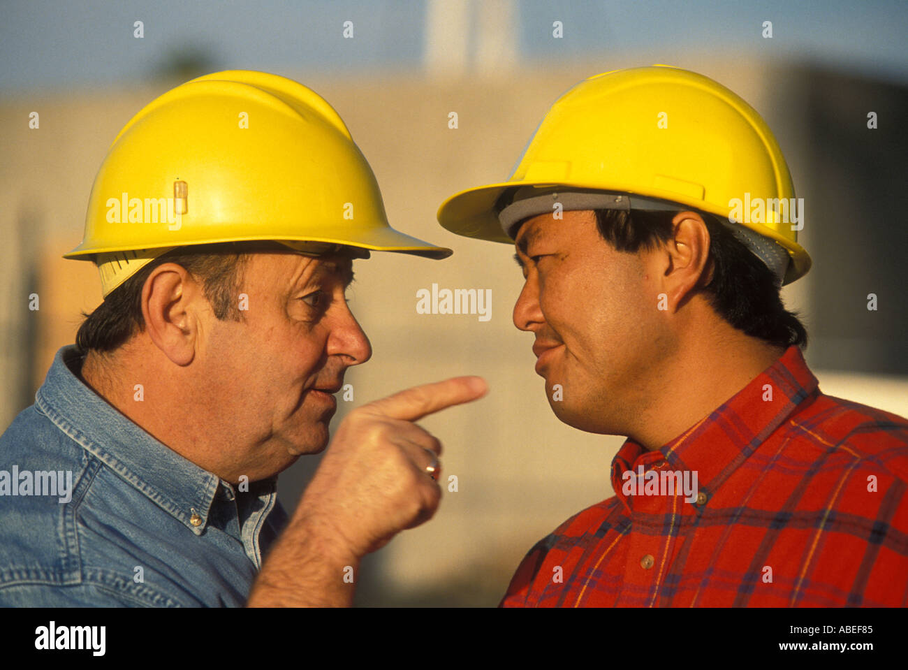 Two construction workers in hardhats having a disagreement Stock Photo ...