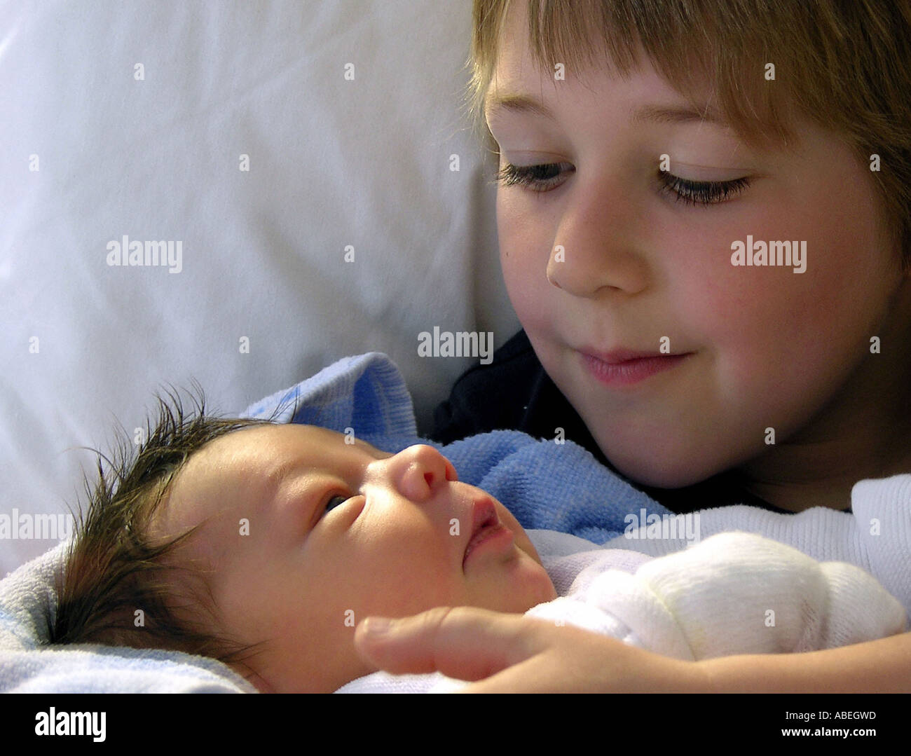 Boy regards its newborn brother Stock Photo - Alamy