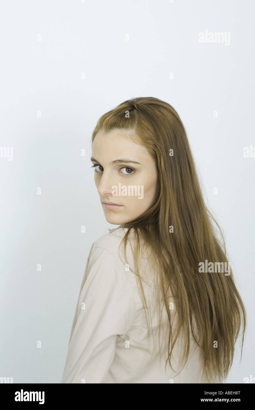Teenage girl looking over shoulder at camera, portrait Stock Photo - Alamy