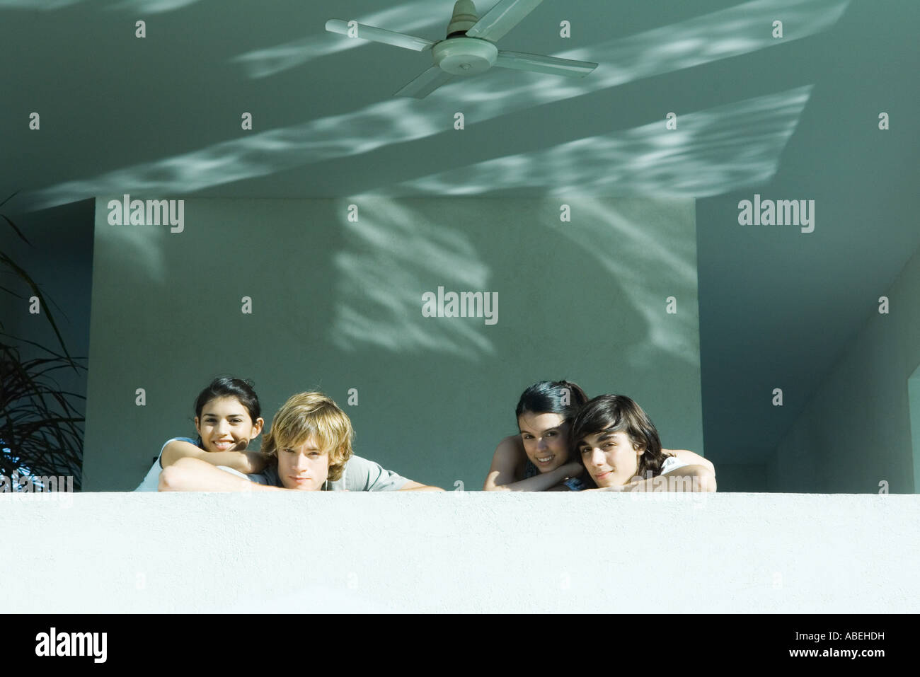 Group of young friends resting heads on arms, smiling at camera Stock ...