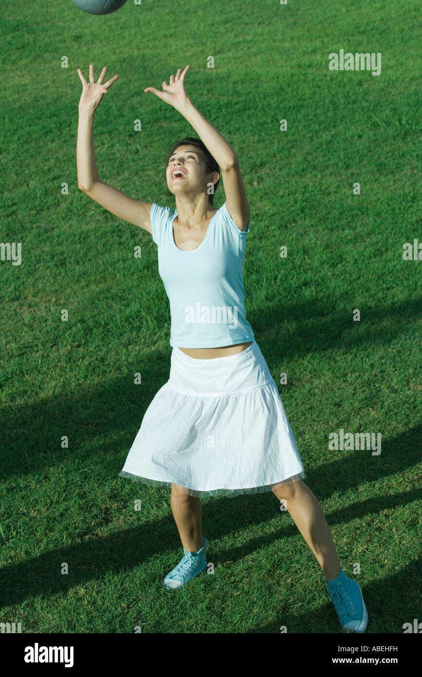Young woman reaching for ball, full length Stock Photo - Alamy