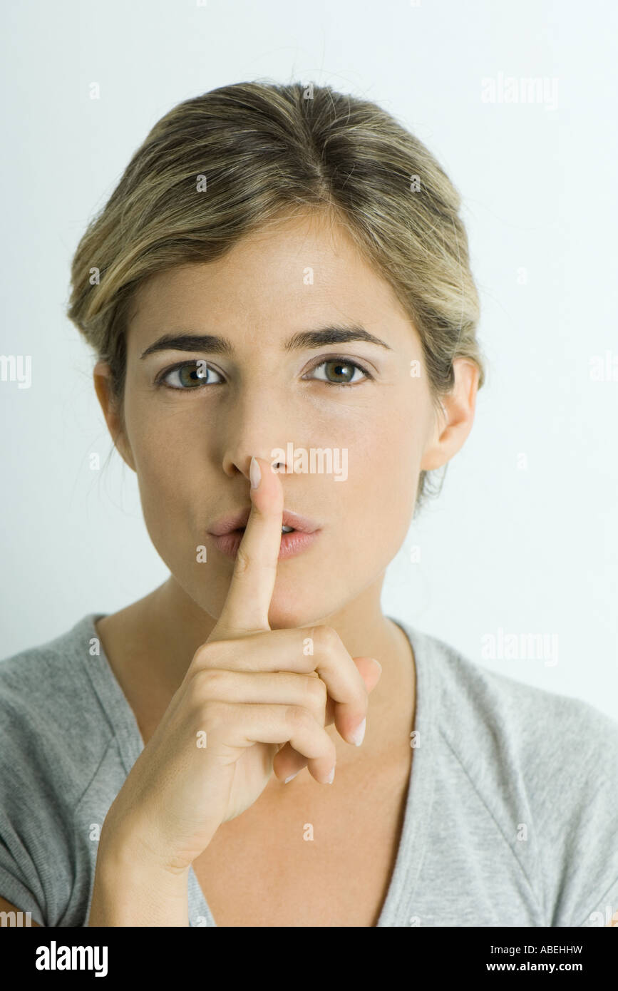 Woman with finger over lips, head and shoulders, portrait Stock Photo ...