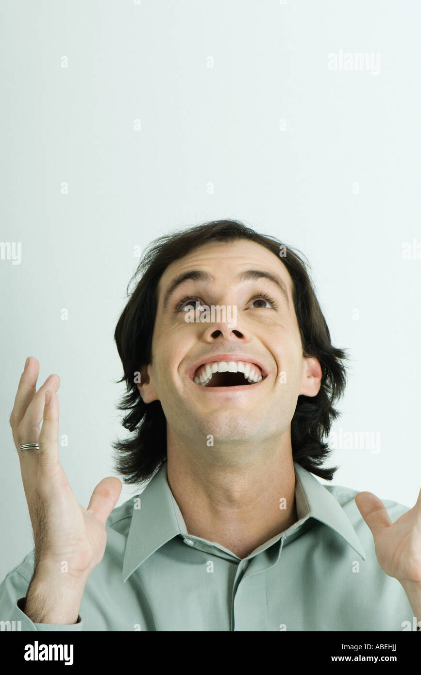 Man, head back and mouth wide open, holding up hands, head and ...