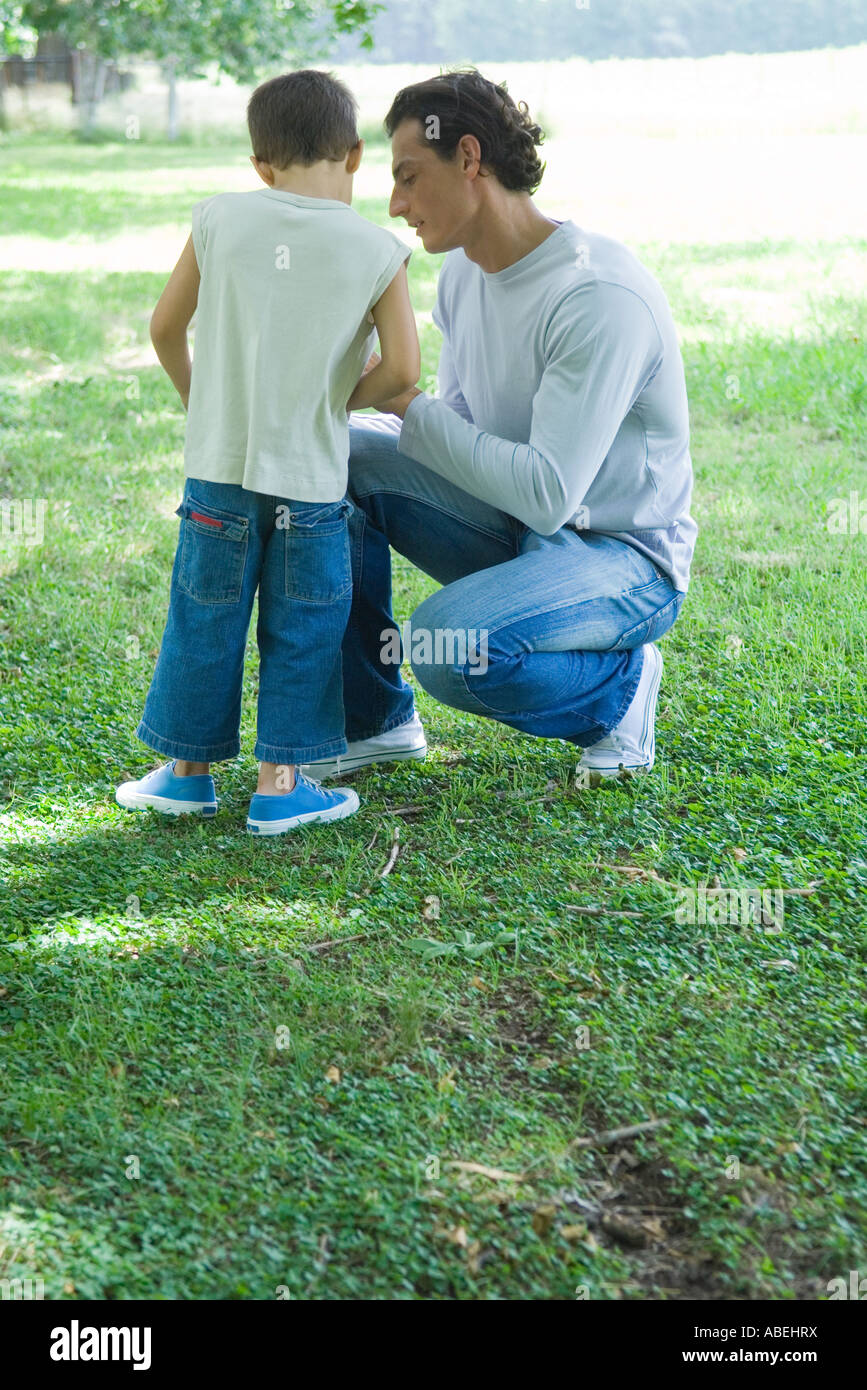 Man crouching next to boy, outdoors Stock Photo - Alamy