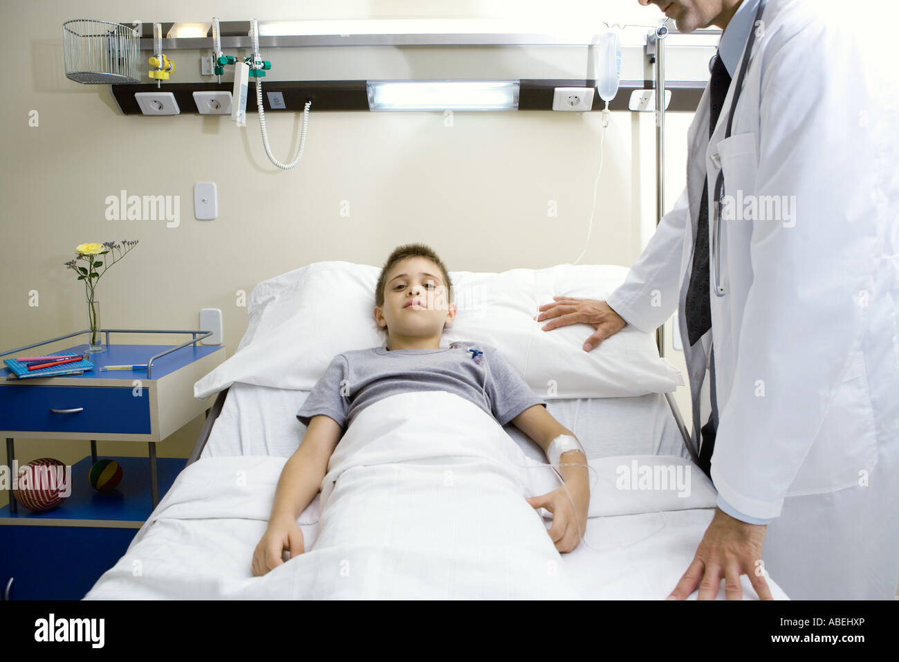 Boy lying in hospital bed, doctor standing by his side Stock Photo - Alamy