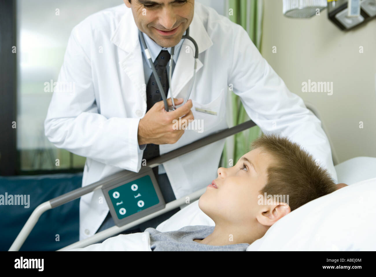 Doctor talking with boy lying in hospital bed Stock Photo - Alamy
