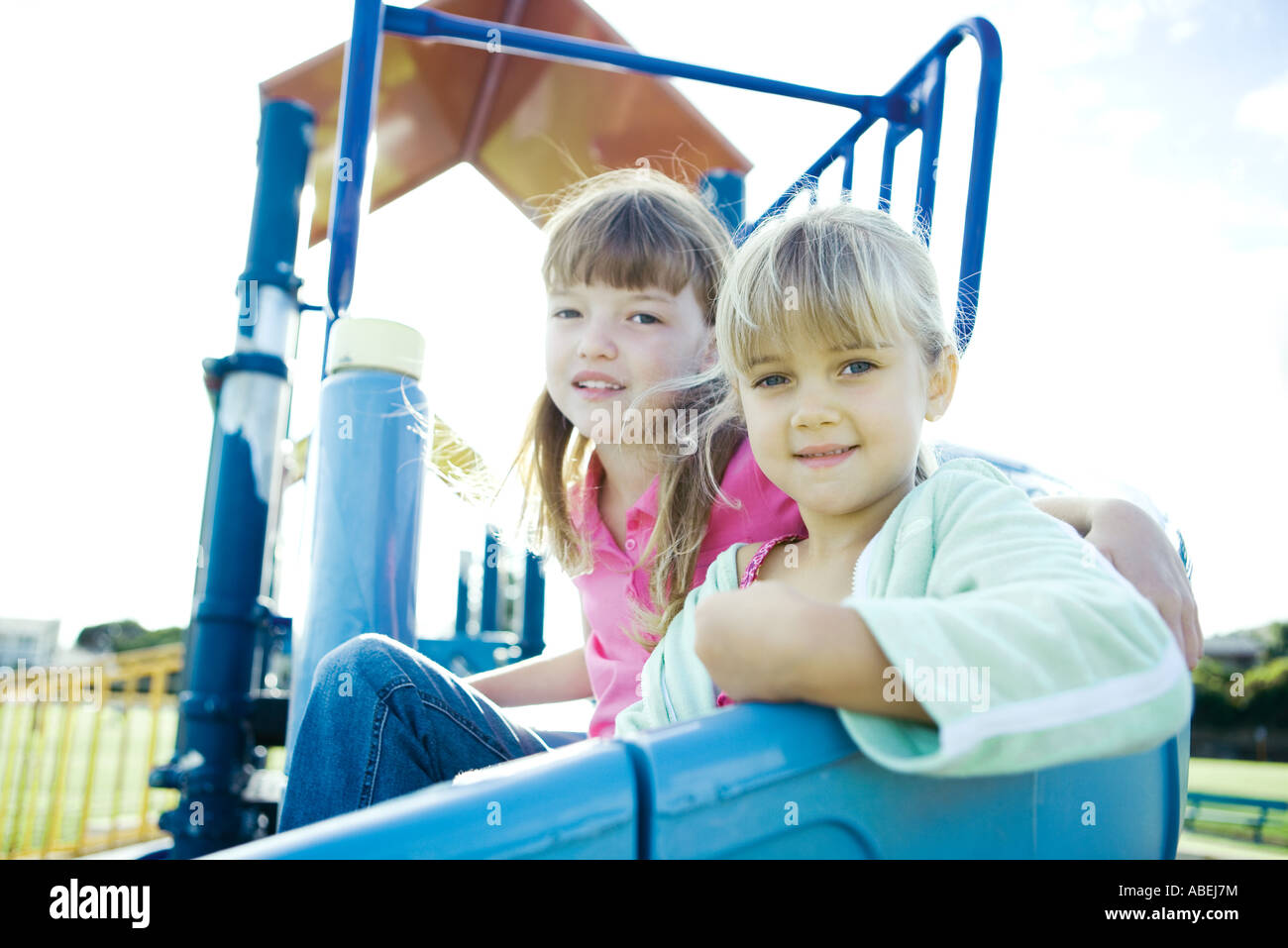 Girls on playground equipment, smiling at camera Stock Photo - Alamy