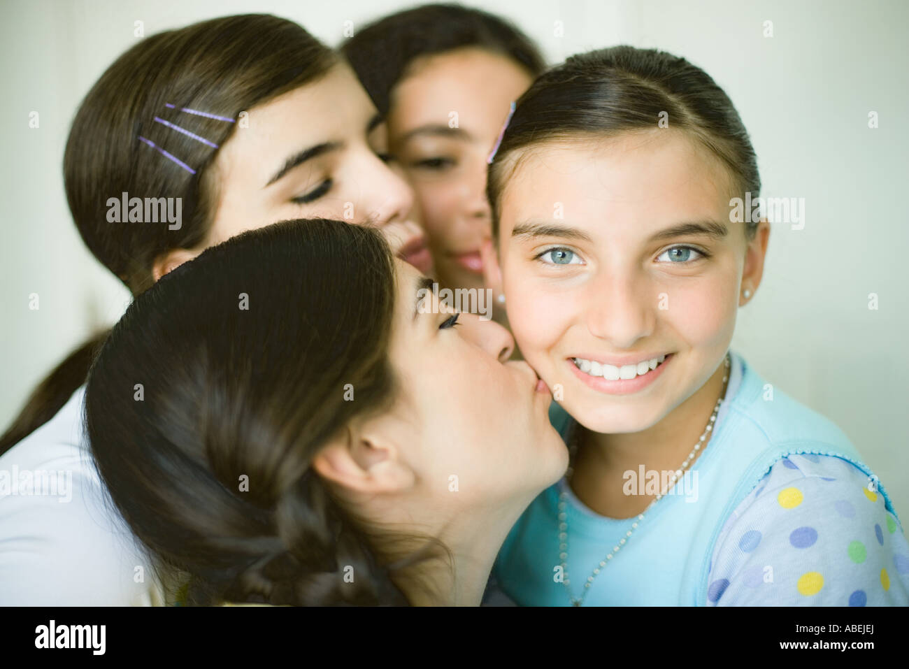 Four young female friends, three kissing one girl's cheek Stock Photo ...