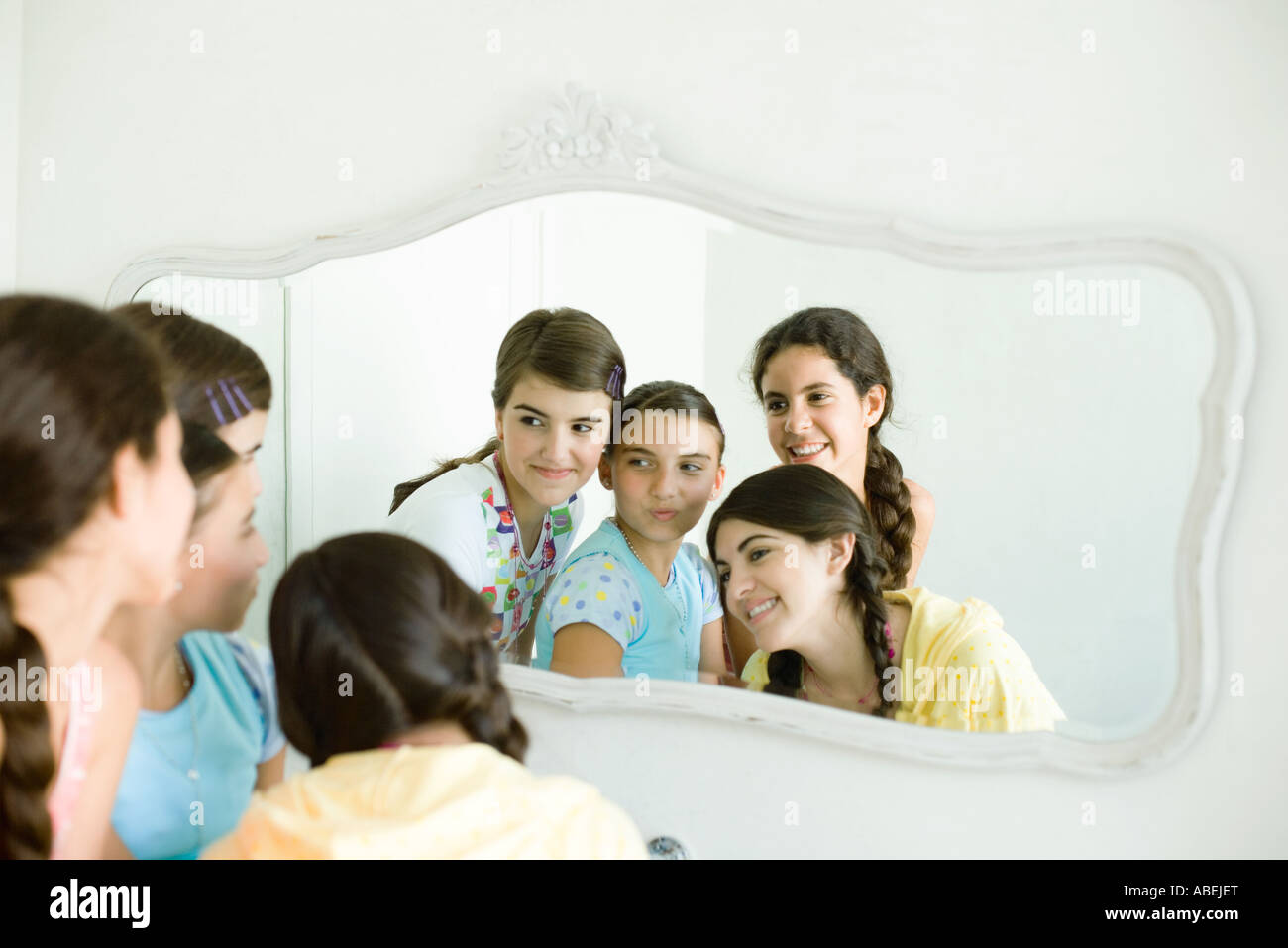Four young female friends looking in mirror together Stock Photo - Alamy