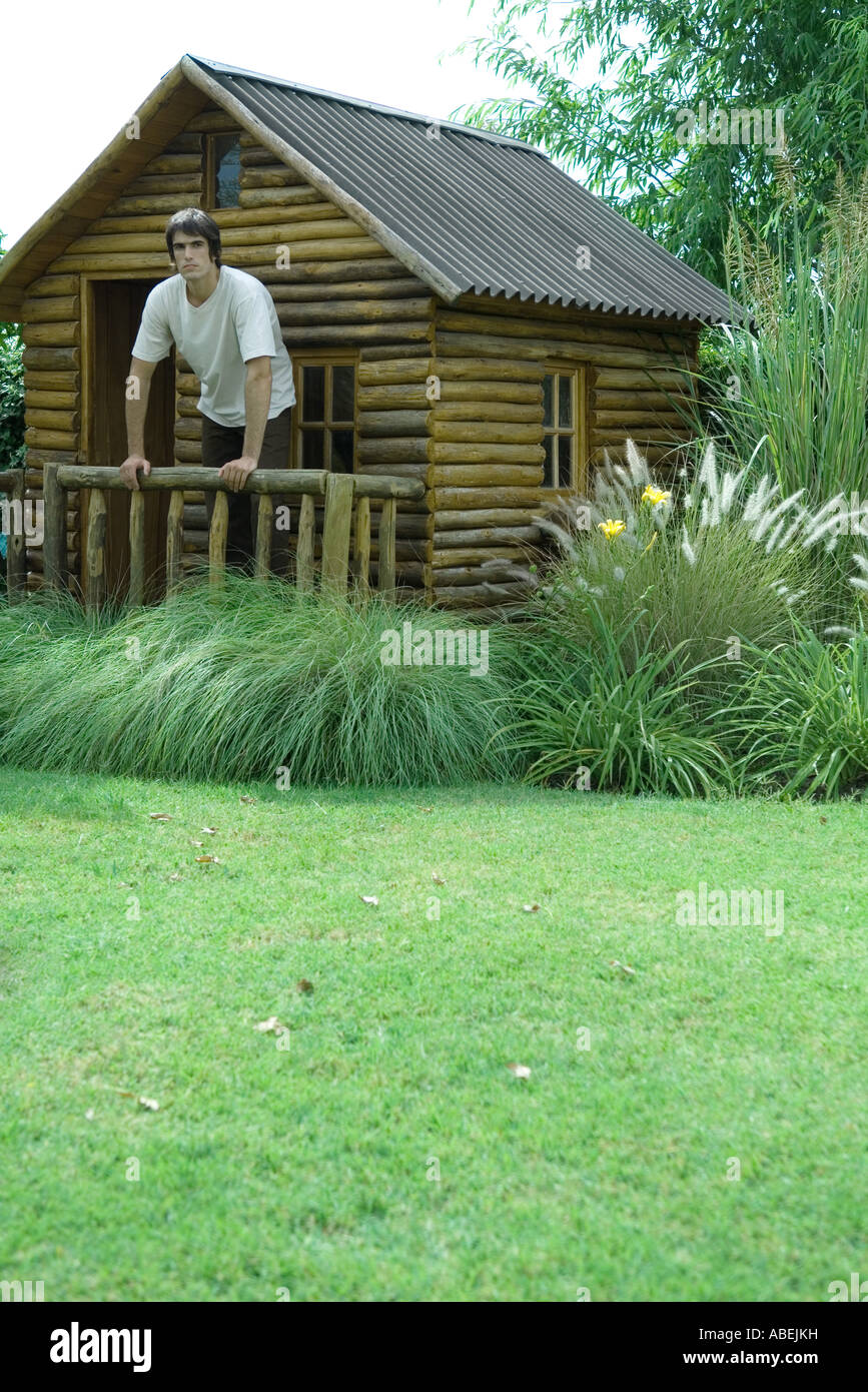 Man standing on porch of log cabin, full length Stock Photo - Alamy