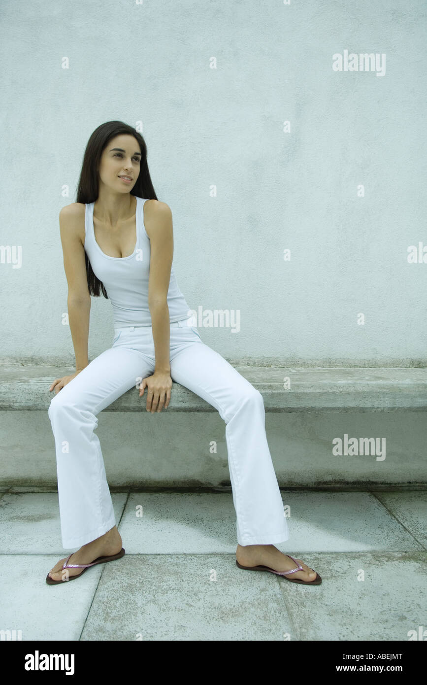 Woman sitting on bench, full length portrait Stock Photo - Alamy