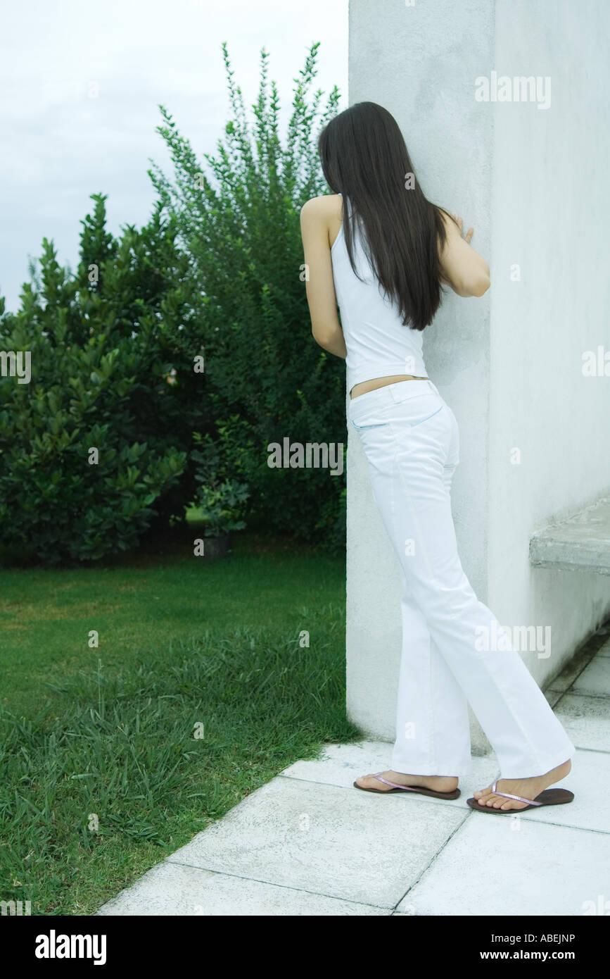 Woman peeking around corner hi-res stock photography and images - Alamy