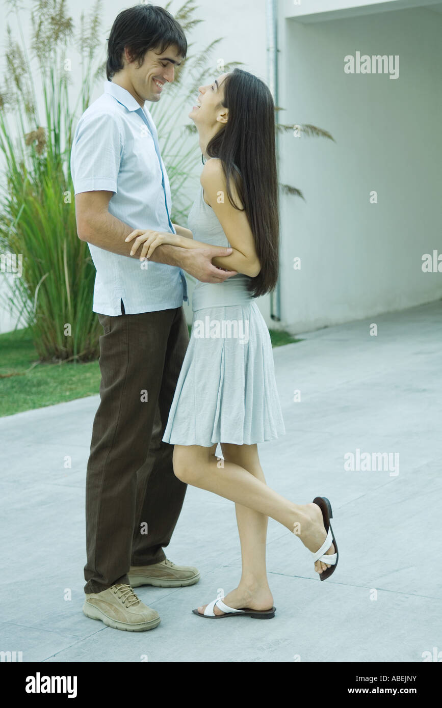 Couple standing holding each other's arms, laughing, full length Stock ...