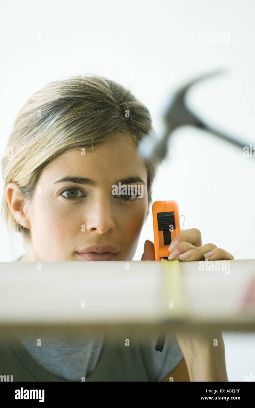 Woman measuring wooden board Stock Photo - Alamy