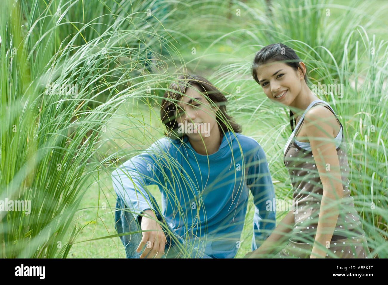 Young couple sitting in grass Stock Photo - Alamy