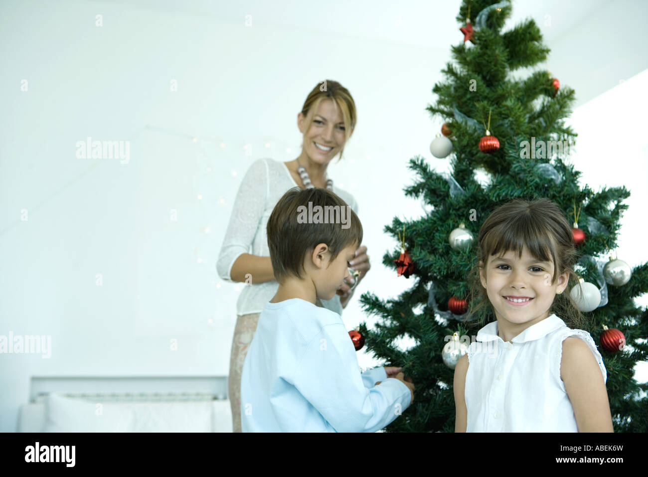 Family decorating Christmas tree Stock Photo - Alamy