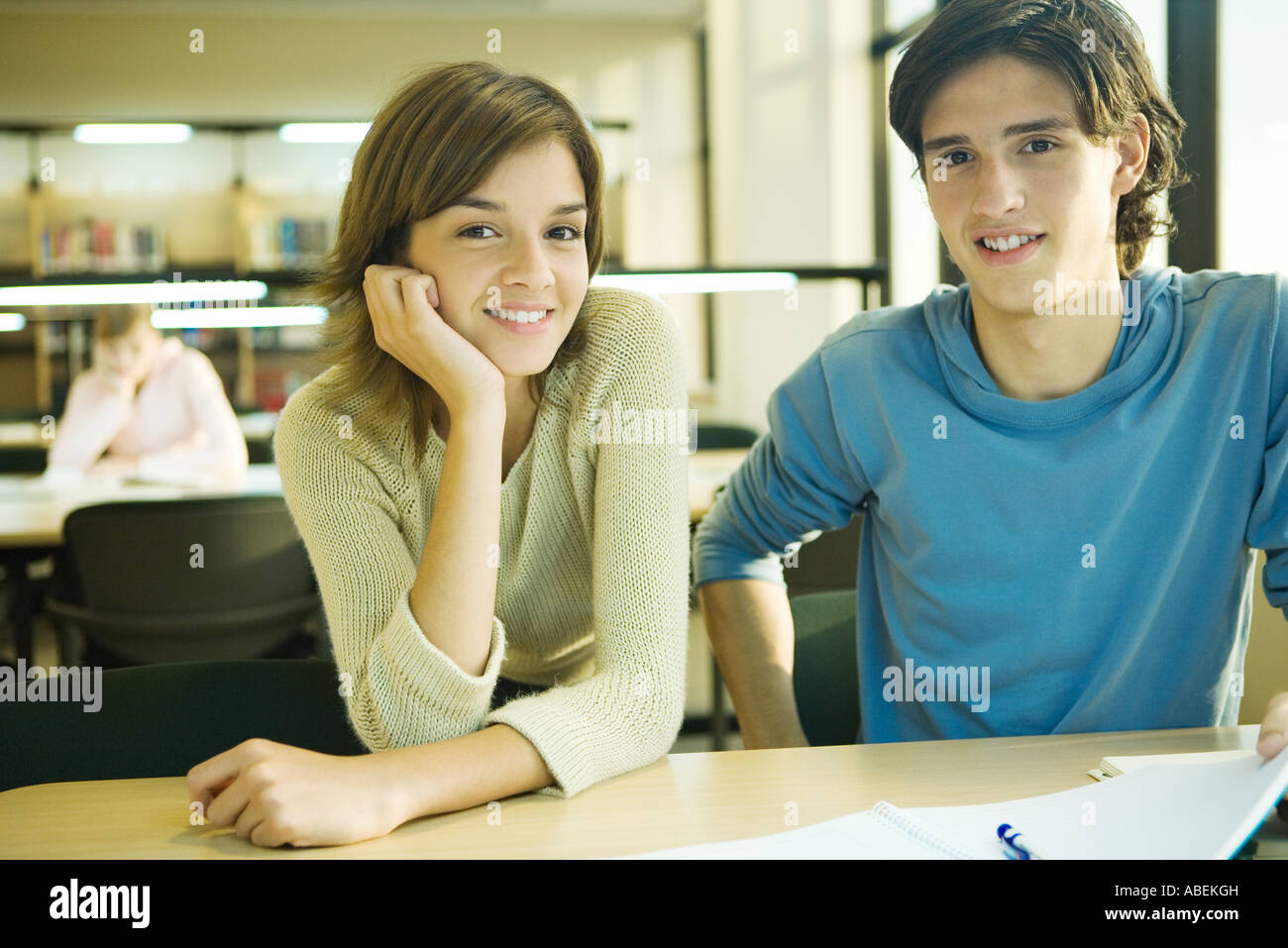 College students sitting at table in library, smiling at camera Stock ...