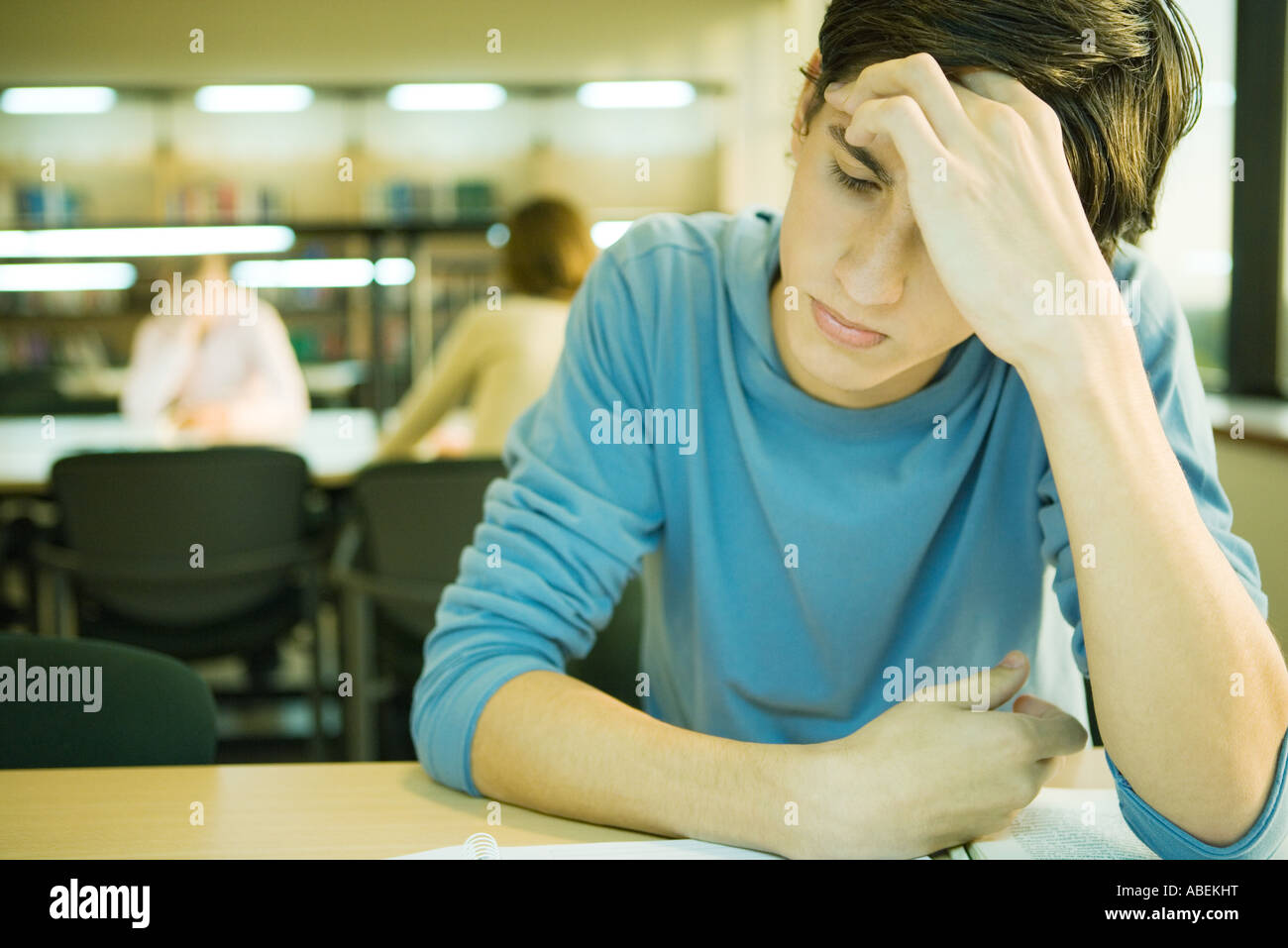 Male college student sitting in library, studying Stock Photo - Alamy