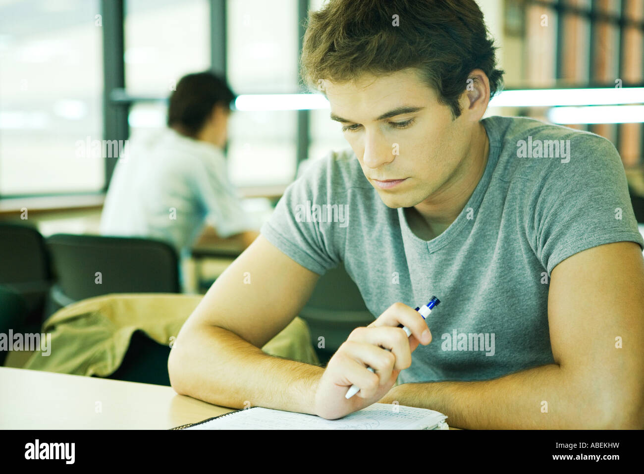 Male college student sitting in library, studying Stock Photo - Alamy