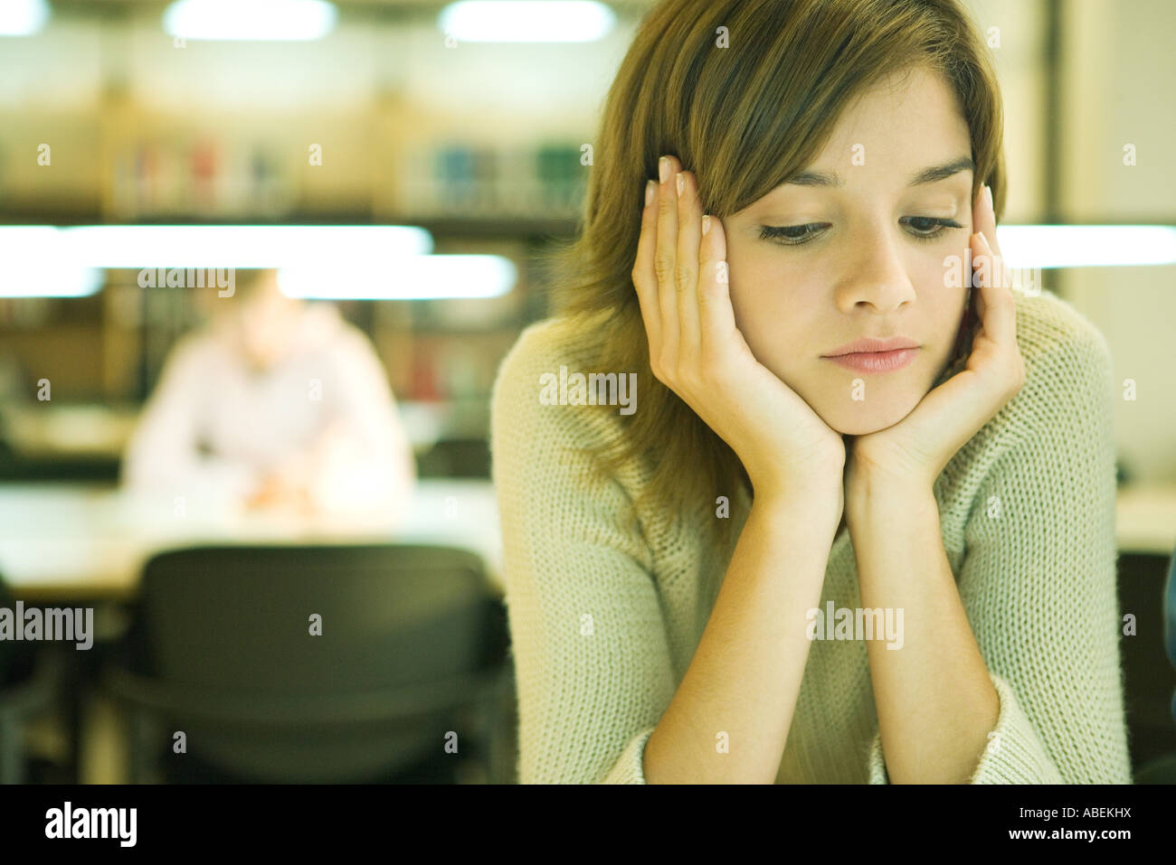 Female college student sitting at table in library, studying Stock ...