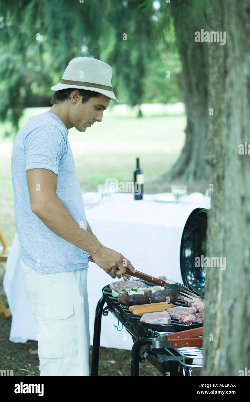 Man grilling meat on barbecue Stock Photo - Alamy