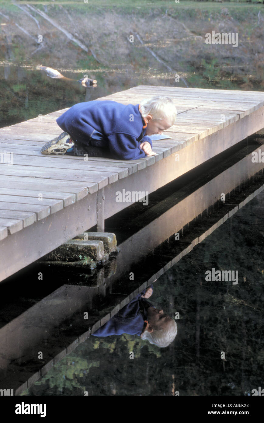 Child looking at reflection in water hi-res stock photography and ...