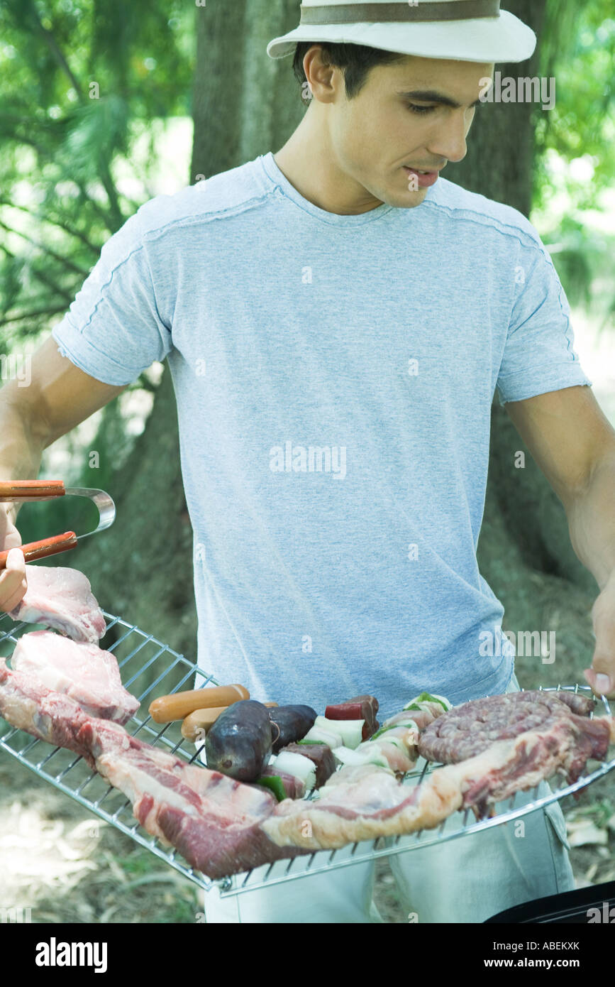 Man holding rack of meats to be grilled Stock Photo - Alamy