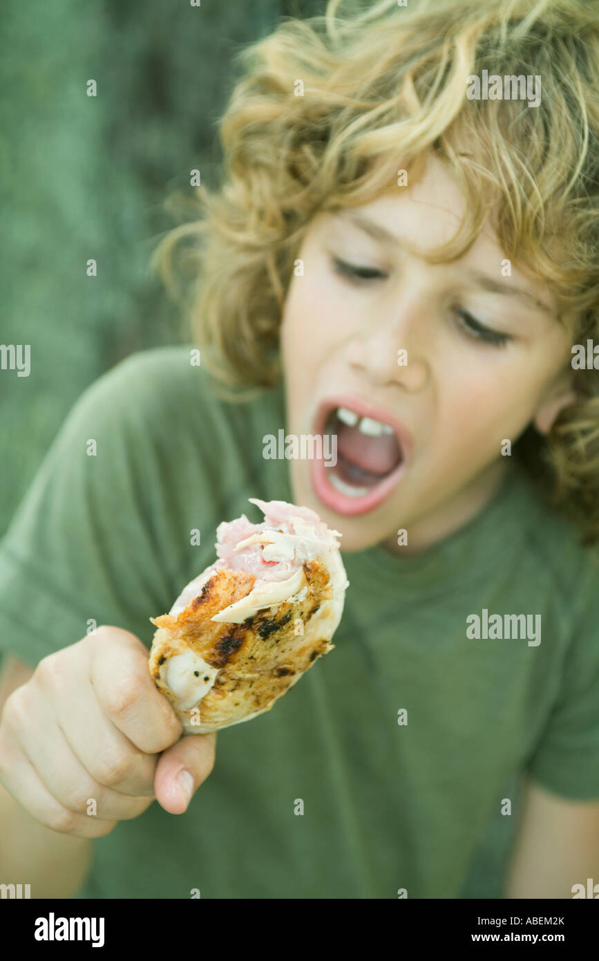 Boy ready to take a bite out of grilled chicken leg Stock Photo - Alamy