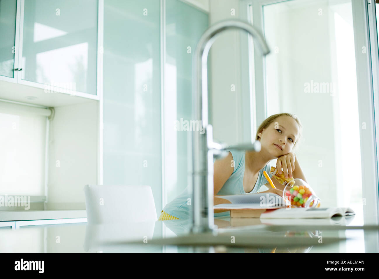 Girl eating sweets and doing homework Stock Photo - Alamy