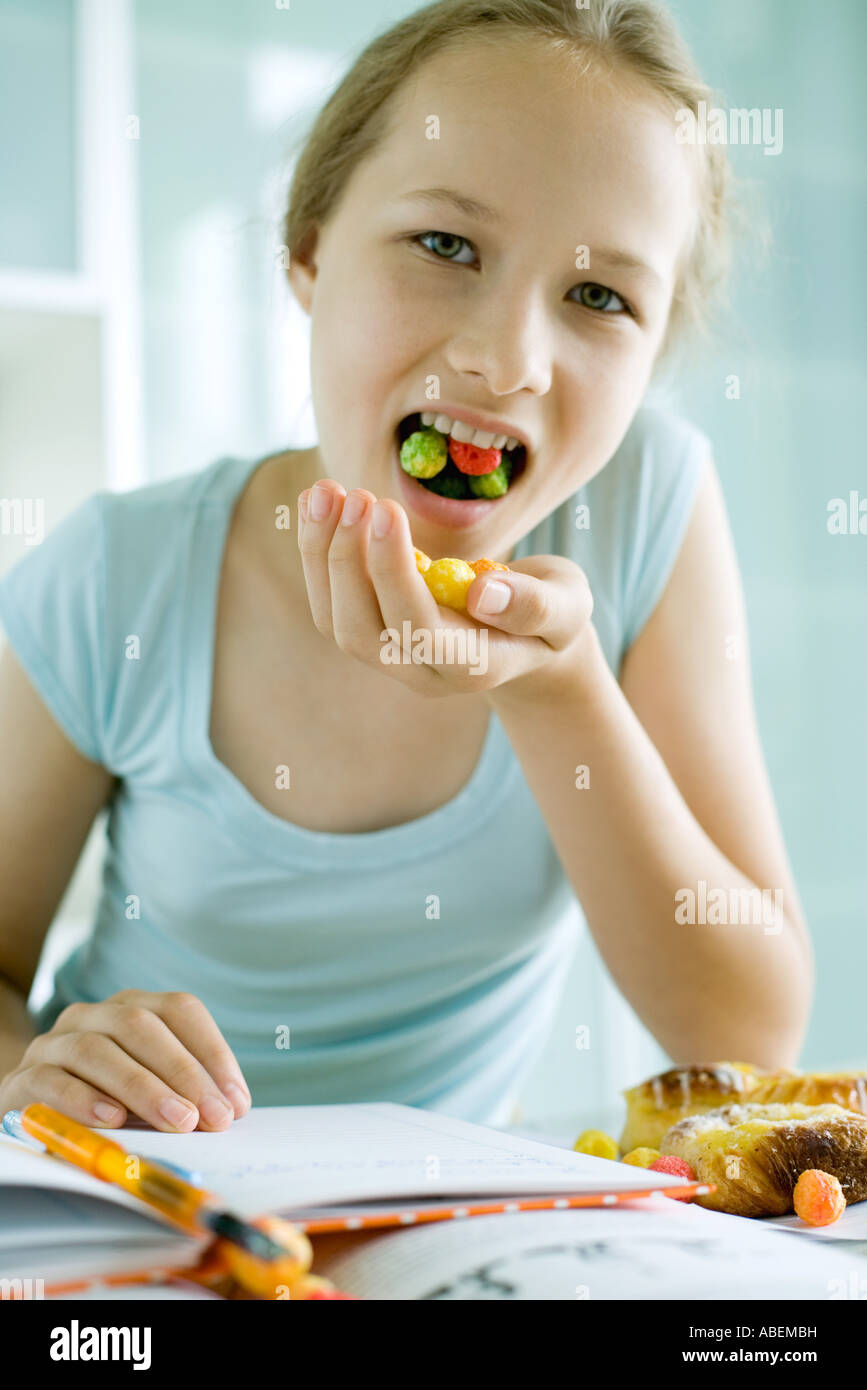 Girl eating sweets and doing homework Stock Photo - Alamy
