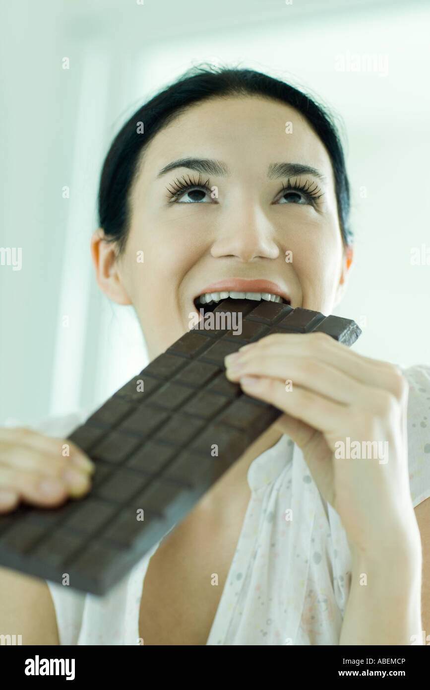 Woman eating large bar of chocolate Stock Photo - Alamy