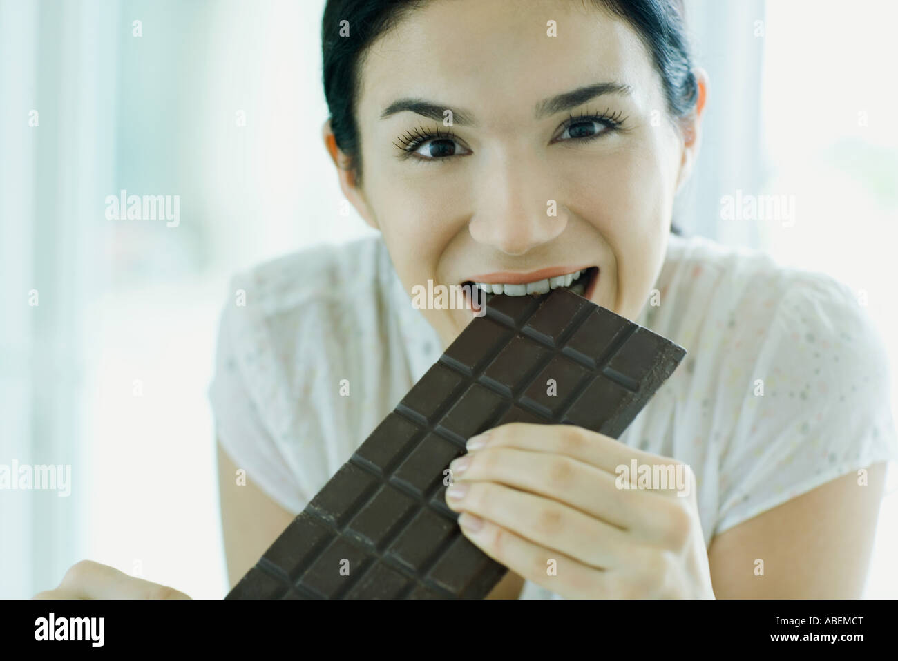 Woman eating large bar of chocolate Stock Photo - Alamy