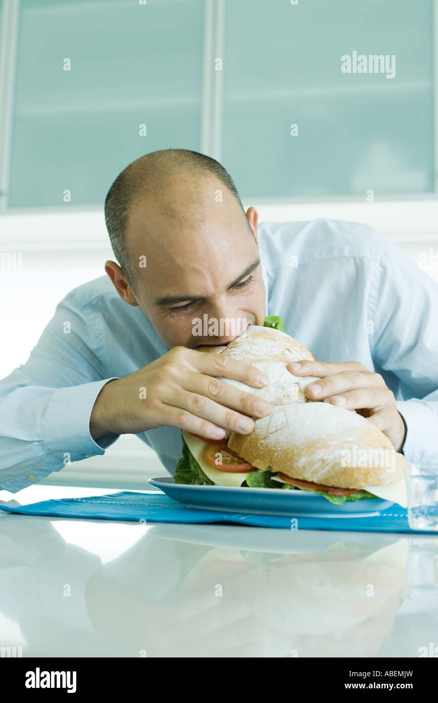Man biting into large sandwich Stock Photo - Alamy