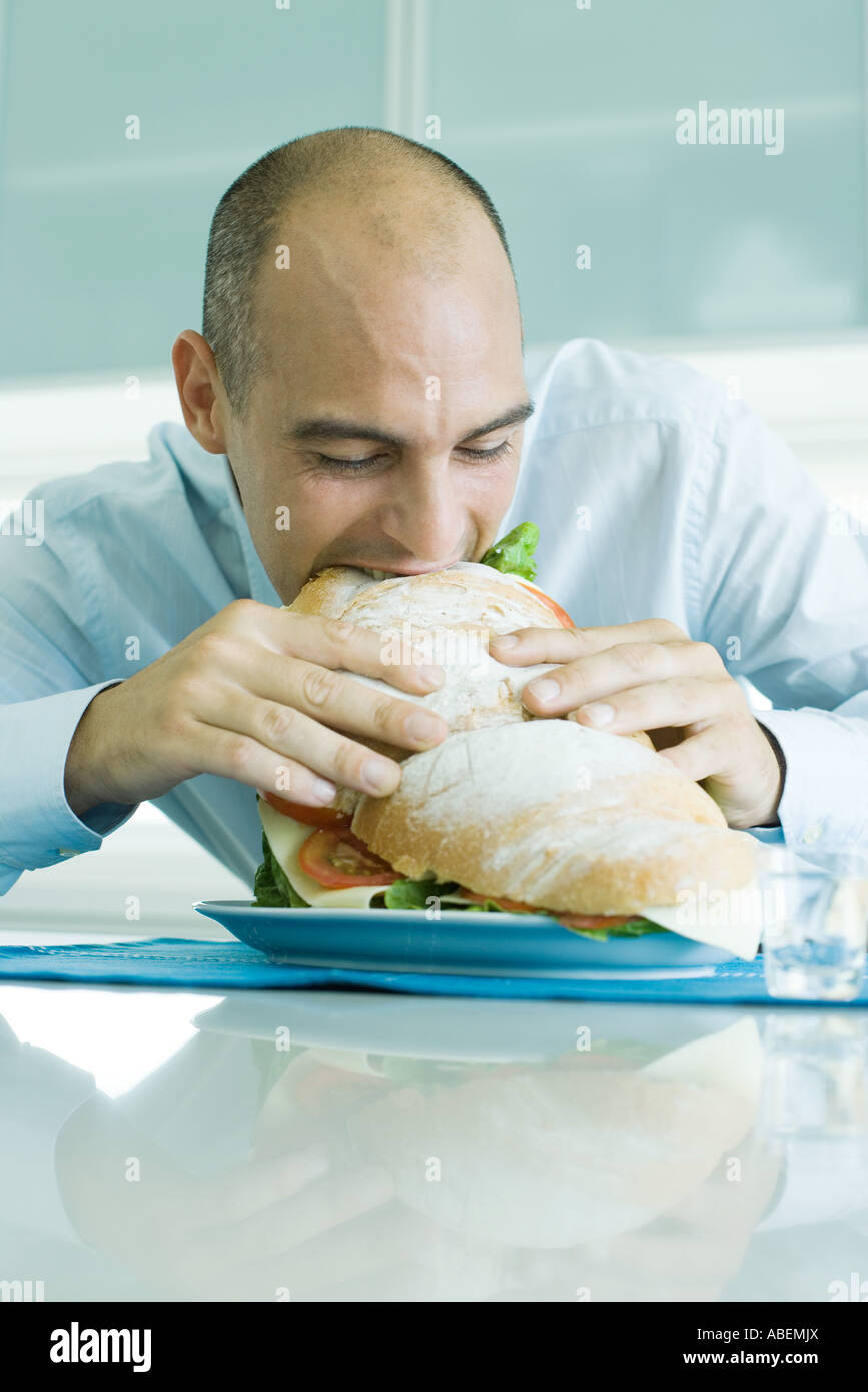 Man biting into large sandwich Stock Photo - Alamy