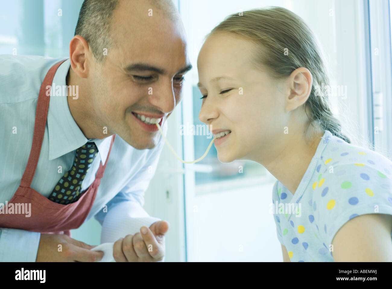 Father and daughter sharing spaghetti noodle, laughing Stock Photo - Alamy