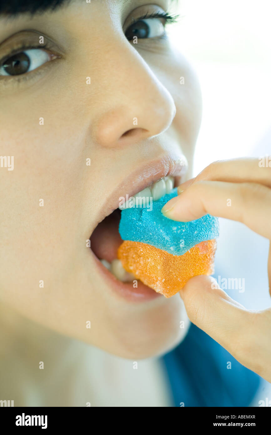 Woman biting into candy, close-up Stock Photo - Alamy