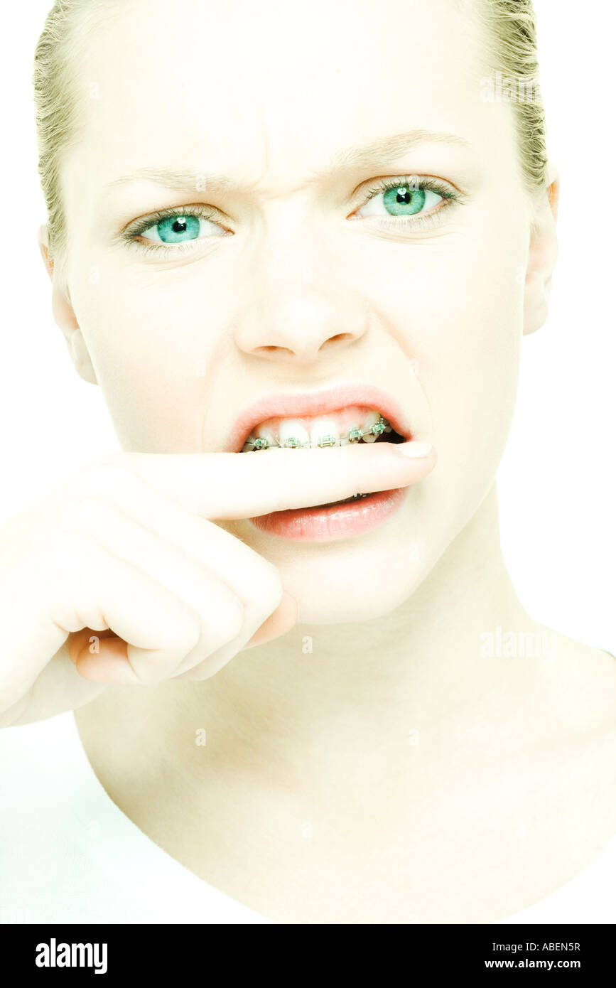 Teenage girl biting finger, close-up Stock Photo - Alamy