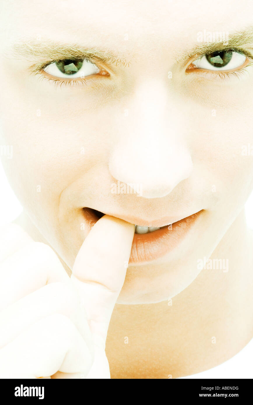 Young man biting thumb Stock Photo - Alamy