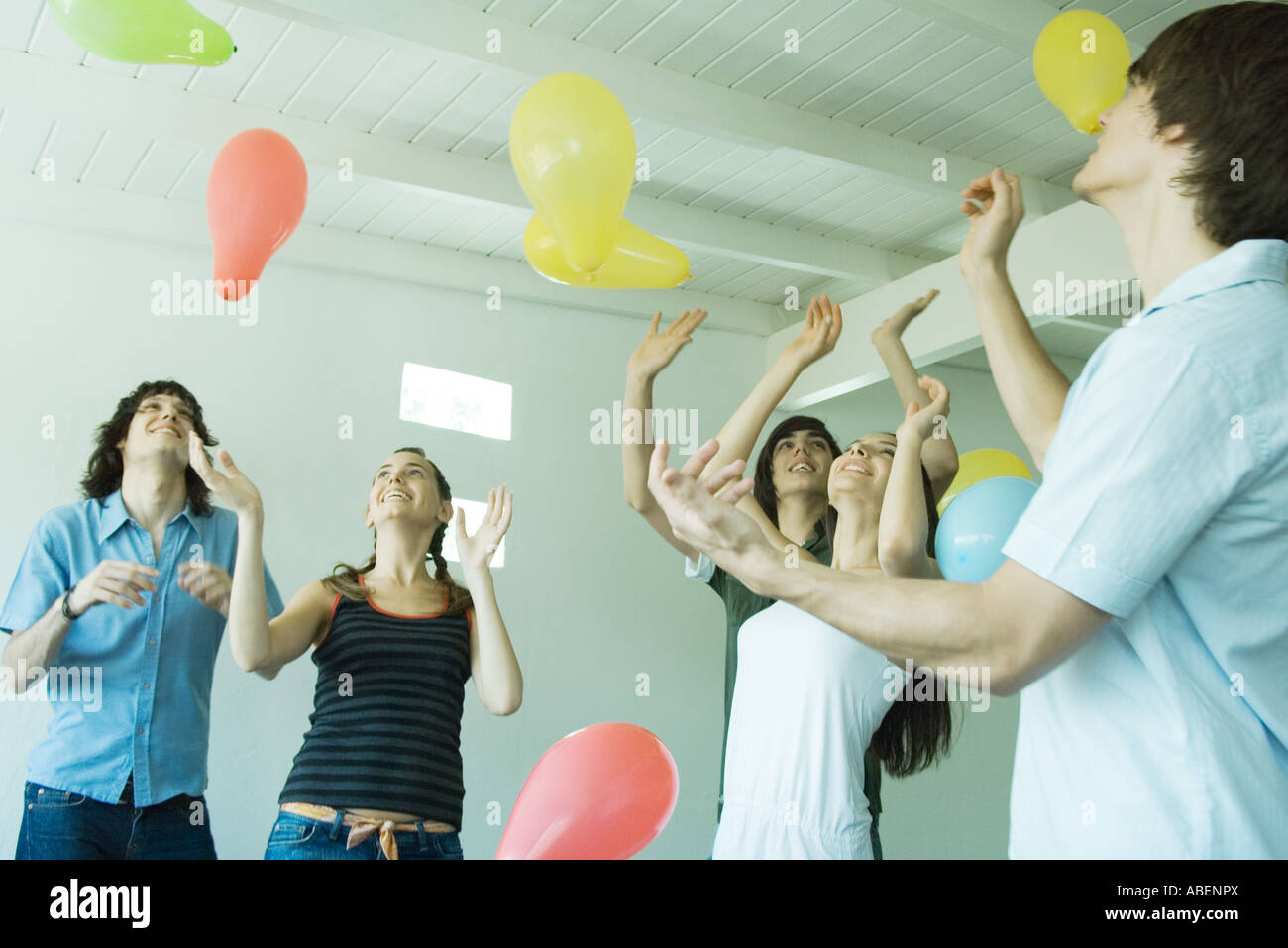 Group of young friends hitting balloons floating in the air Stock Photo ...