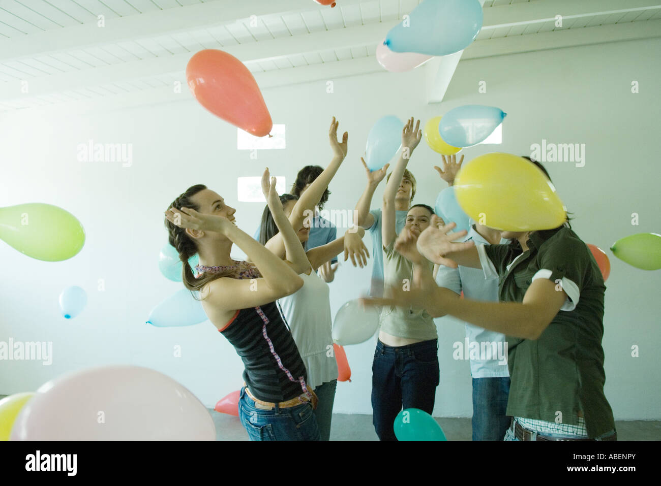 Group of young friends hitting balloons floating in the air Stock Photo ...